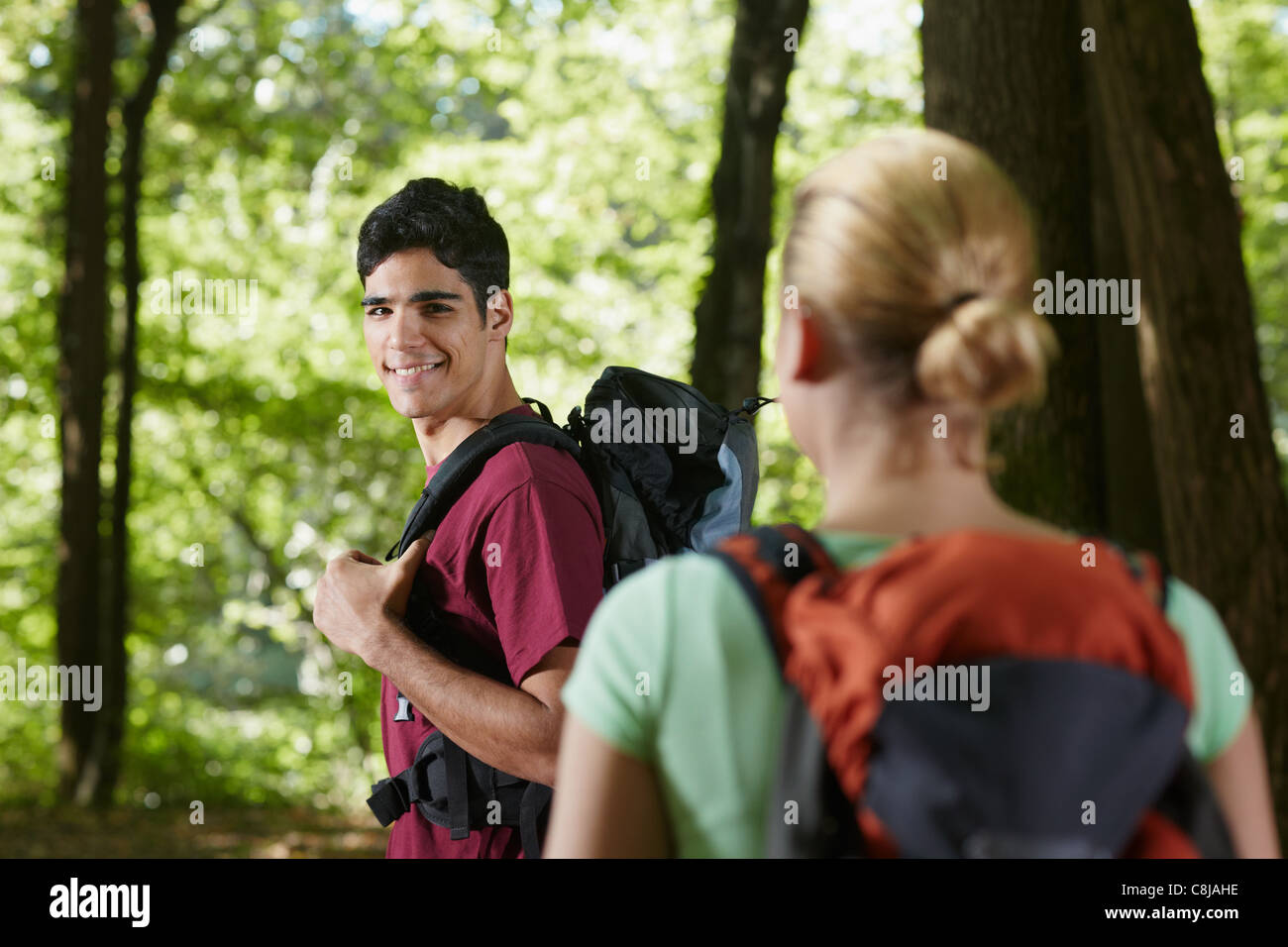 young man and woman during hiking excursion, with man looking over ...