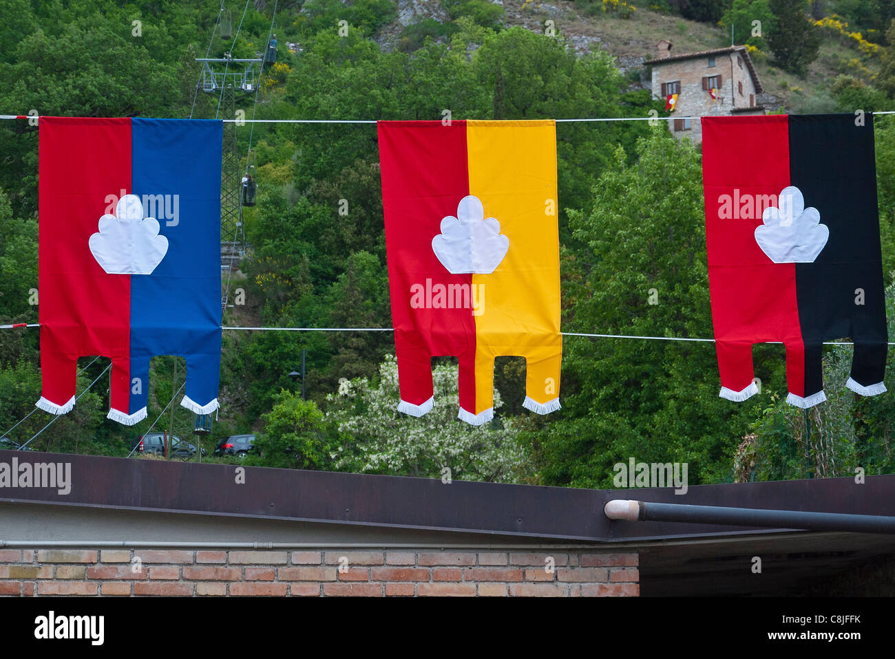 Colorful banners hang in the town of Gubbio, Italy representing three ...