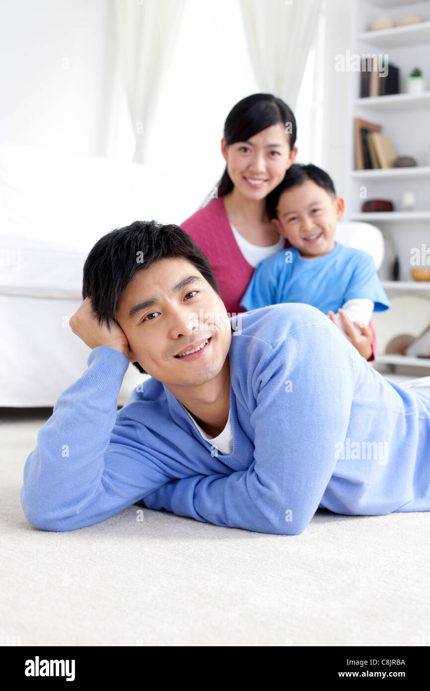 Young Chinese family, father lying on floor Stock Photo - Alamy