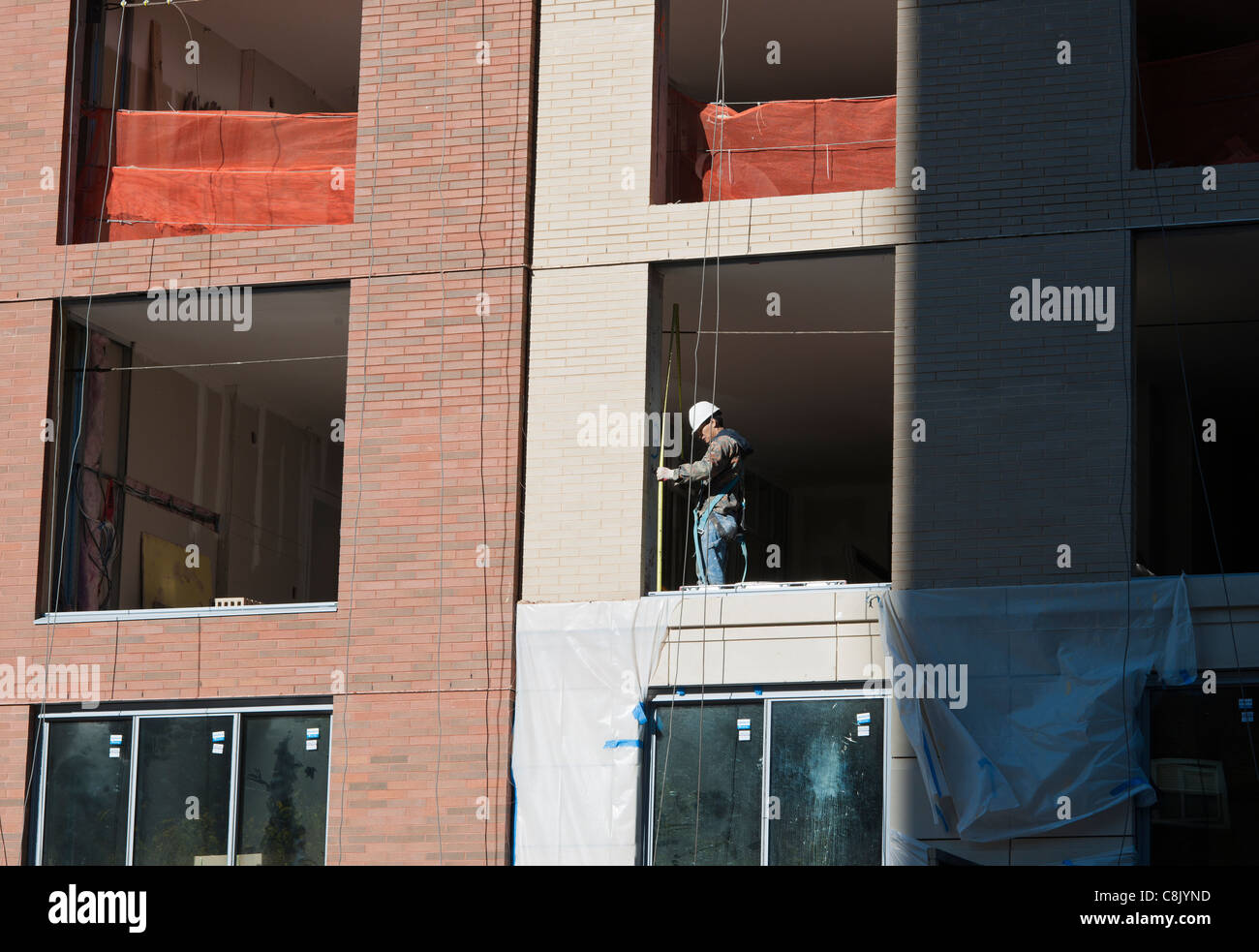 Construction worker building an affordable housing apartment building ...