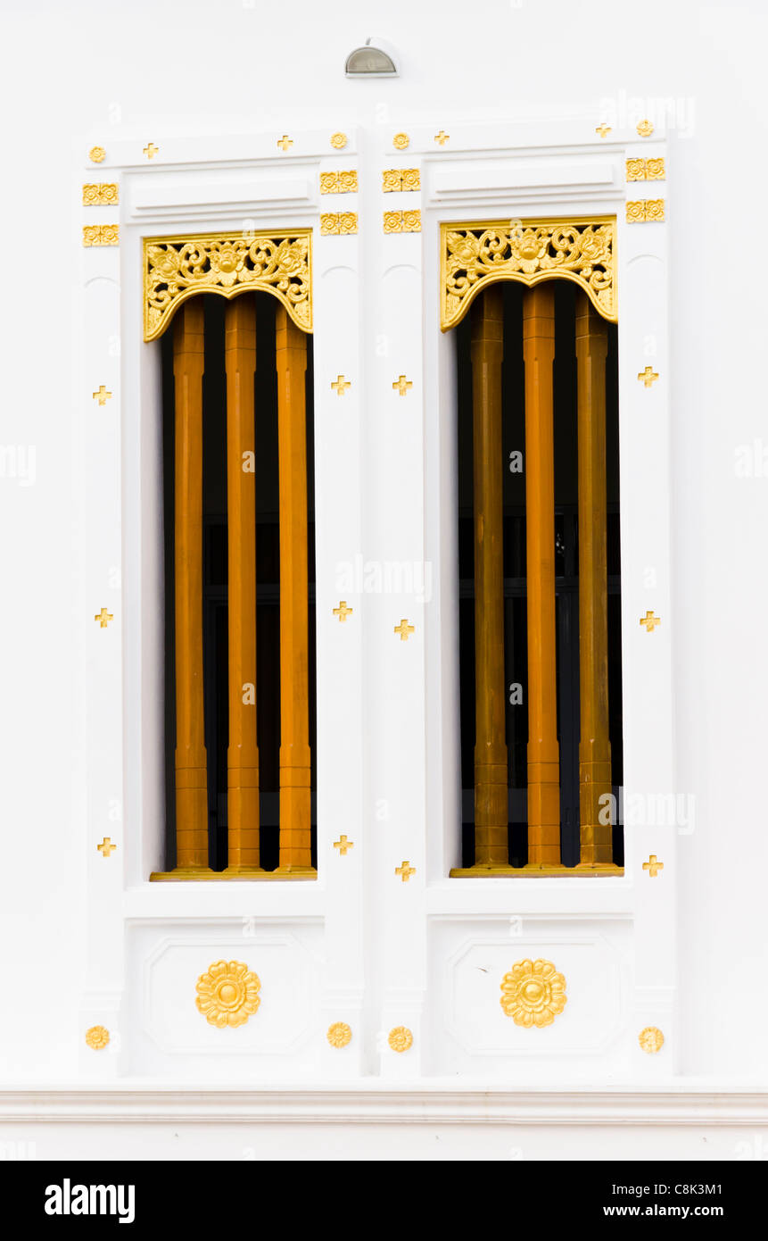 Closeup of ornate gold decorated windows with vertical carved wooden ...