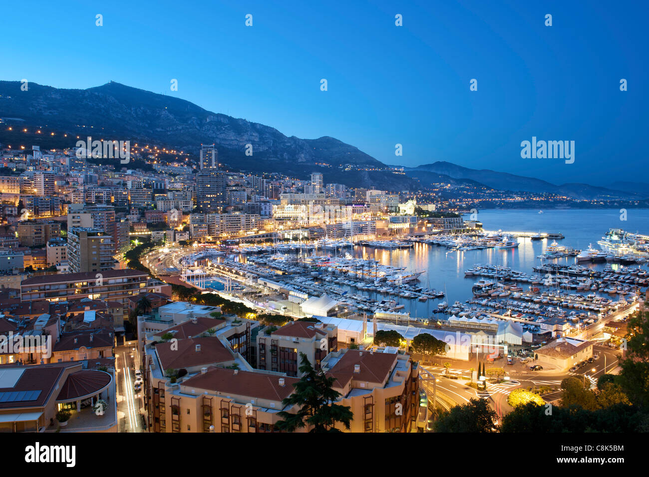Dusk view of Port Hercule and the city and Principality of Monaco on ...