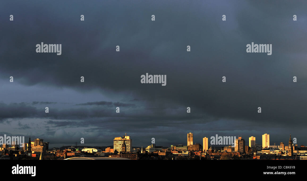 Sunlit Glasgow skyline under a dark, brooding sky Stock Photo - Alamy