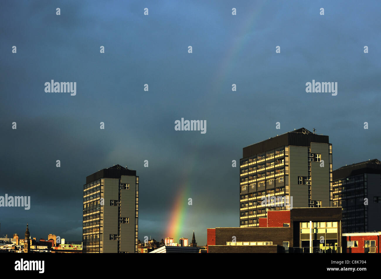 Rainbow over the Gorbals, Glasgow with sunlit buildings under a dark ...