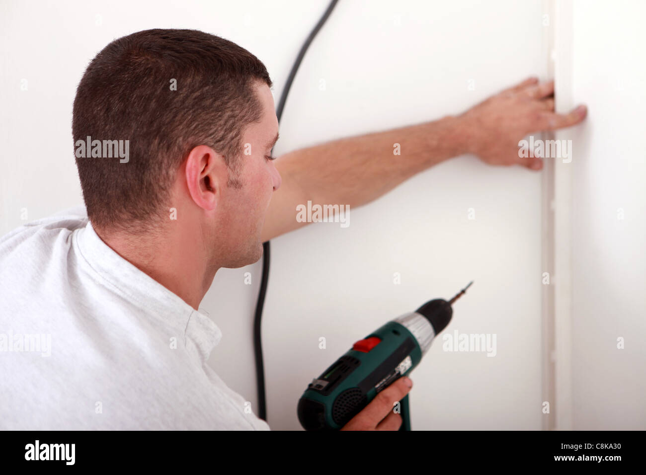 Workman using drill Stock Photo - Alamy