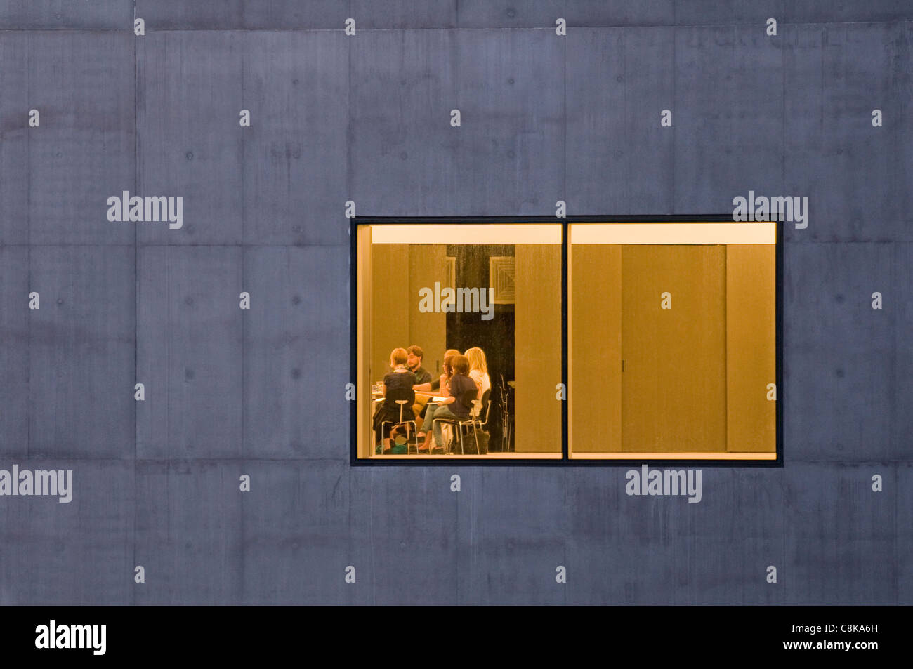 View through glass window (golden glow of lights & people sitting ...