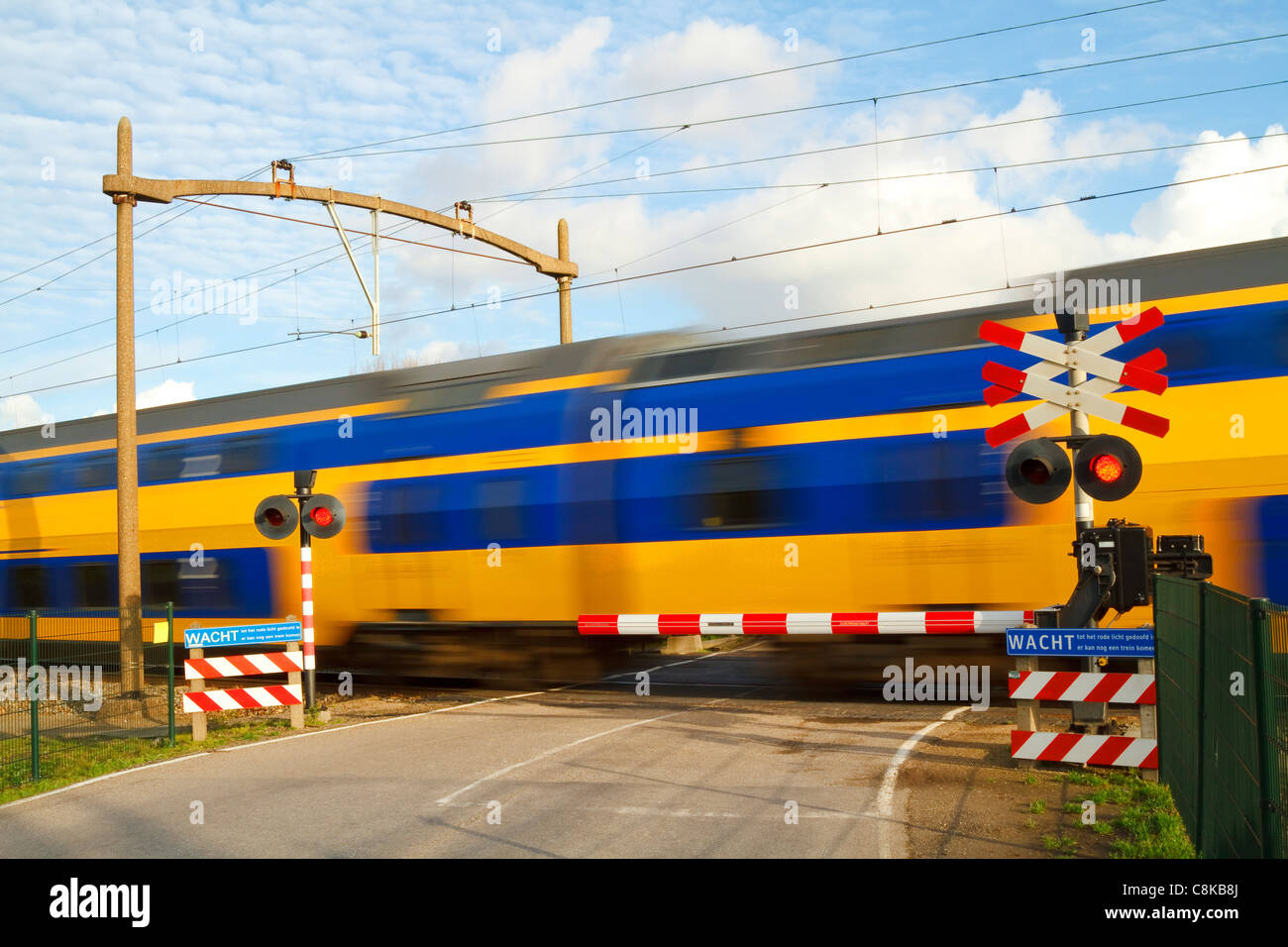 Dutch yellow and blue intercity high speed train passing a railway ...