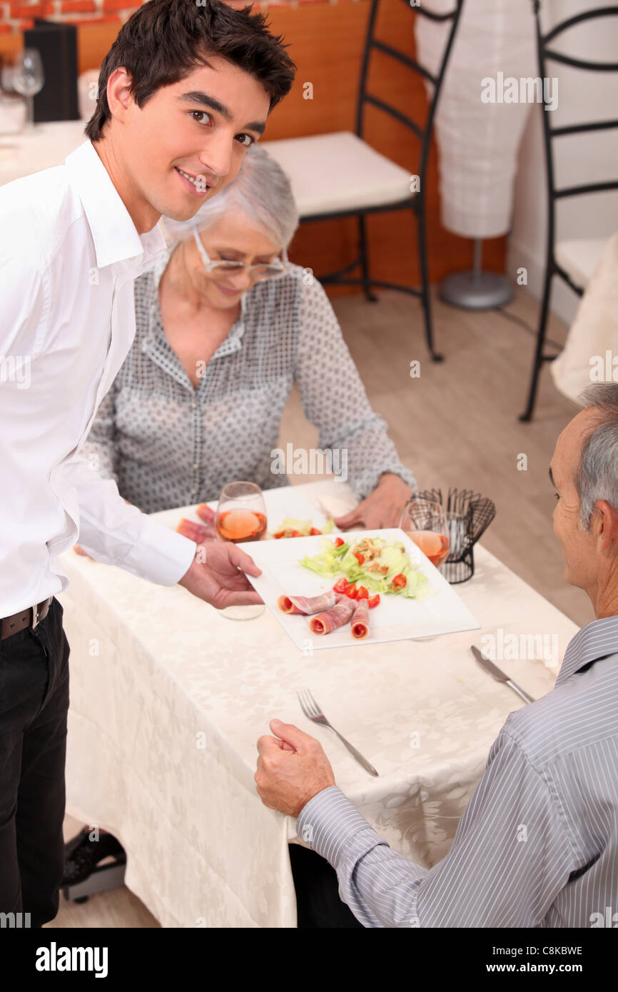 Waiter serving a meal Stock Photo - Alamy
