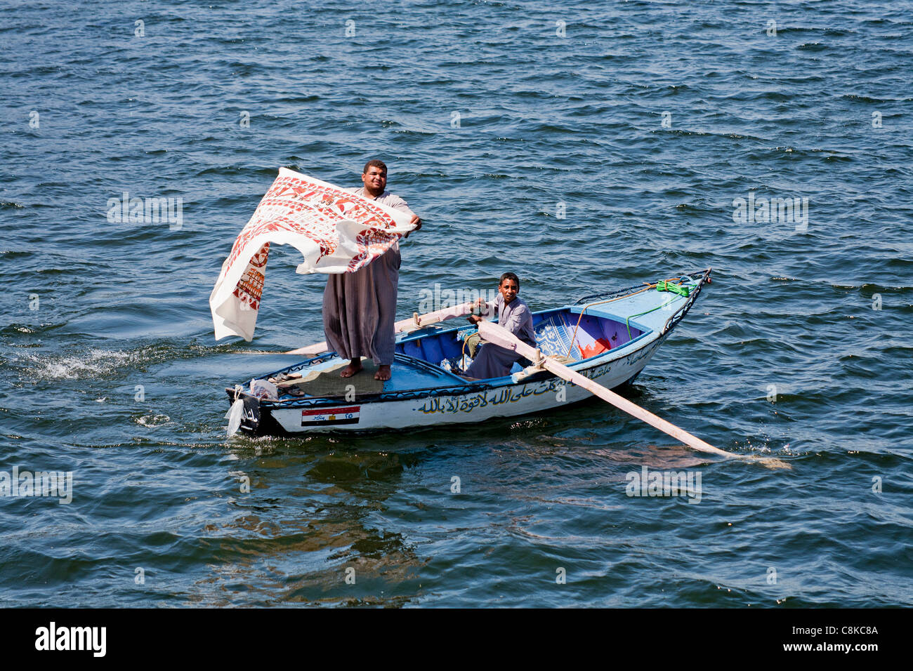 Two market traders in a small boat in Esna lock Egypt surrounded by ...