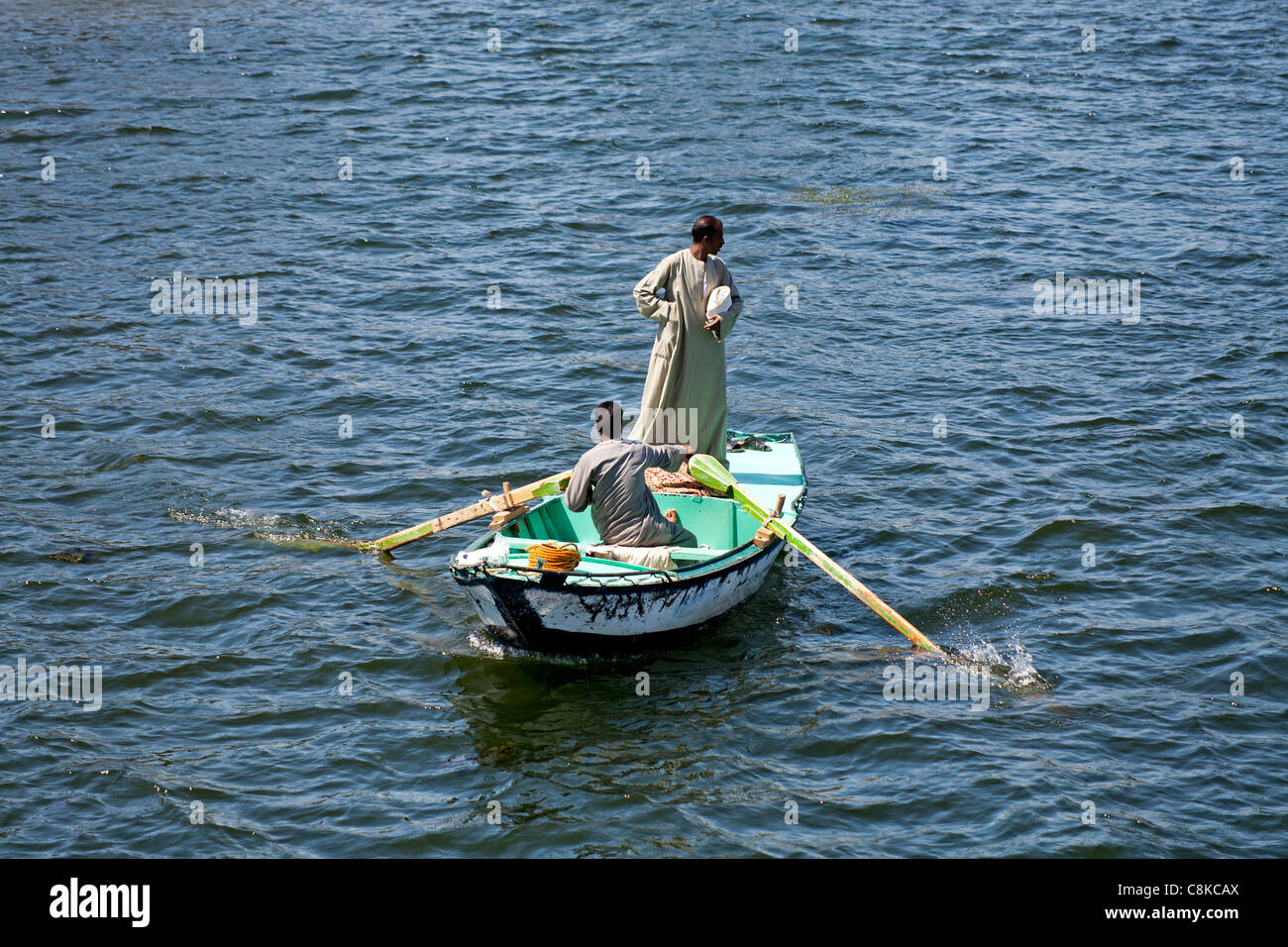 Two market traders rowing a small blue boat in Esna lock Egypt ...