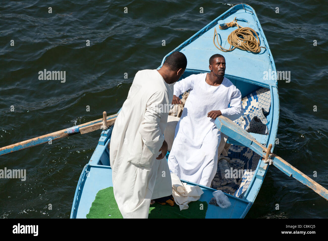 Two market traders rowing a small blue boat in Esna lock Egypt ...