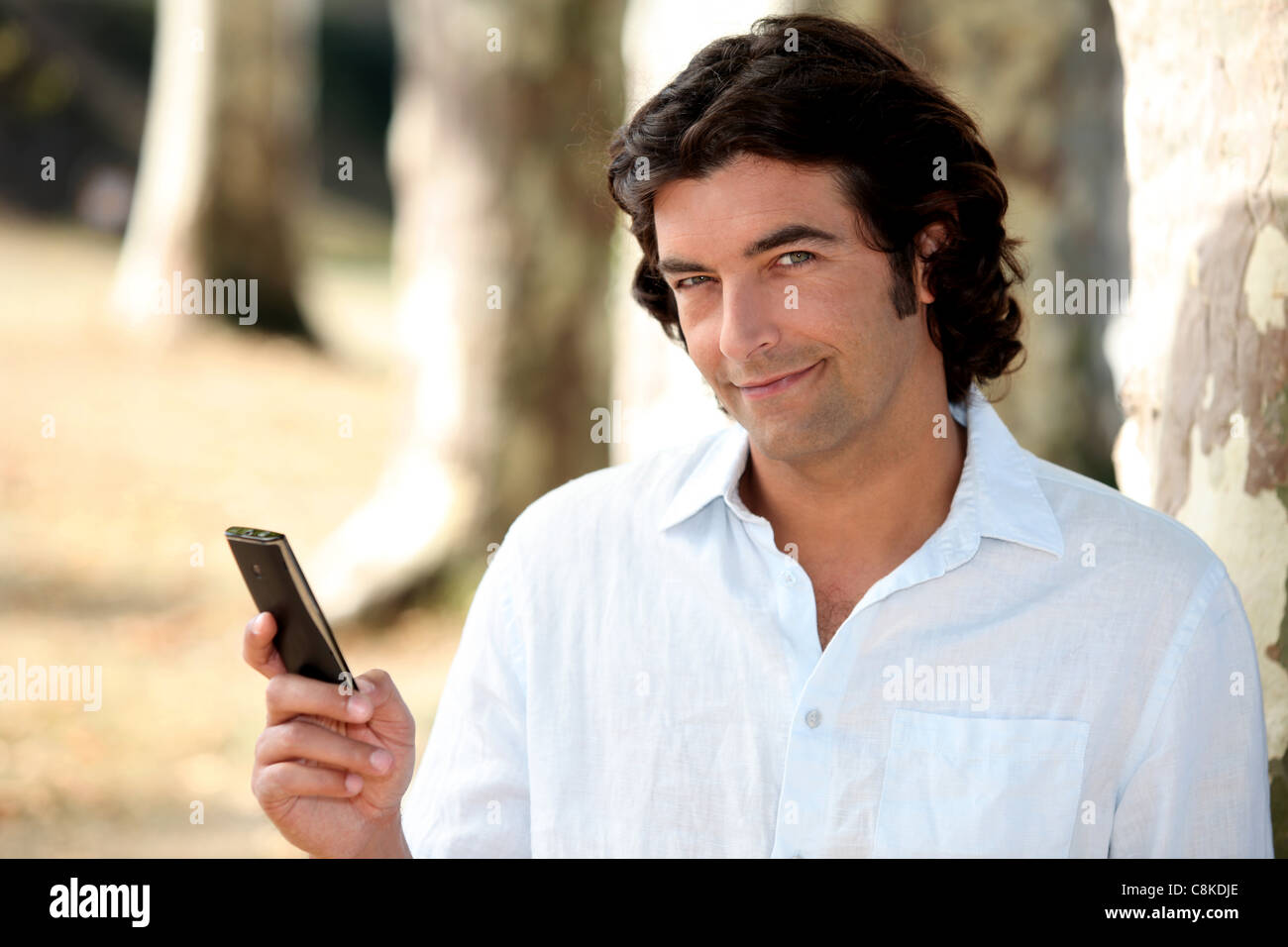 Man sending a text message in the forest Stock Photo - Alamy