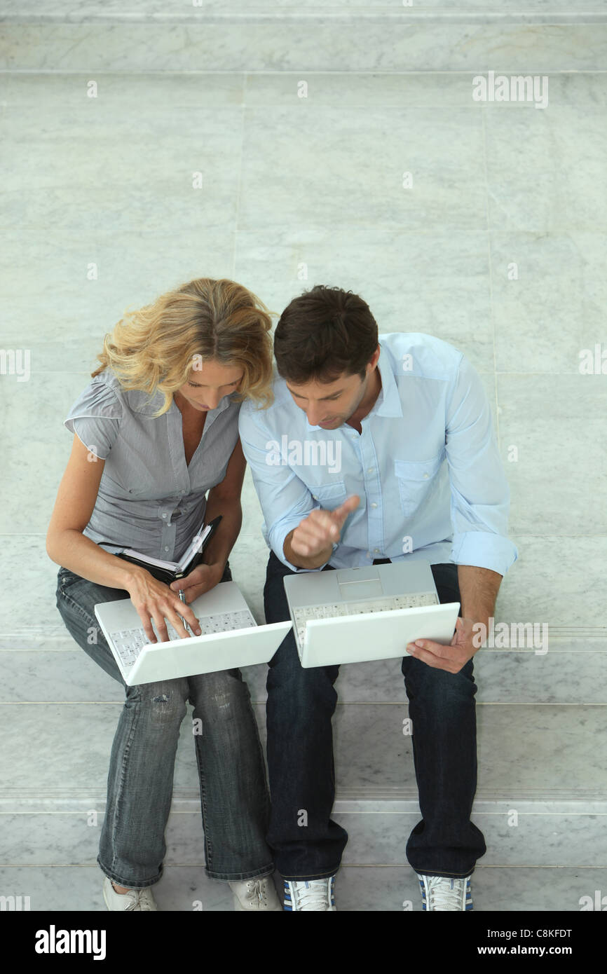 Couple with two computers Stock Photo - Alamy