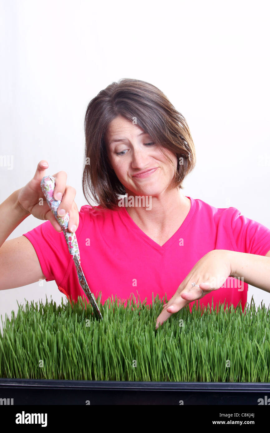 A young woman gardening looking in the grass Stock Photo - Alamy