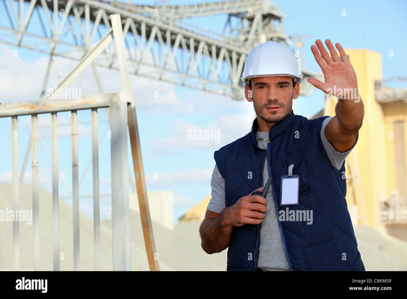 worker on a construction site waving his hand Stock Photo - Alamy