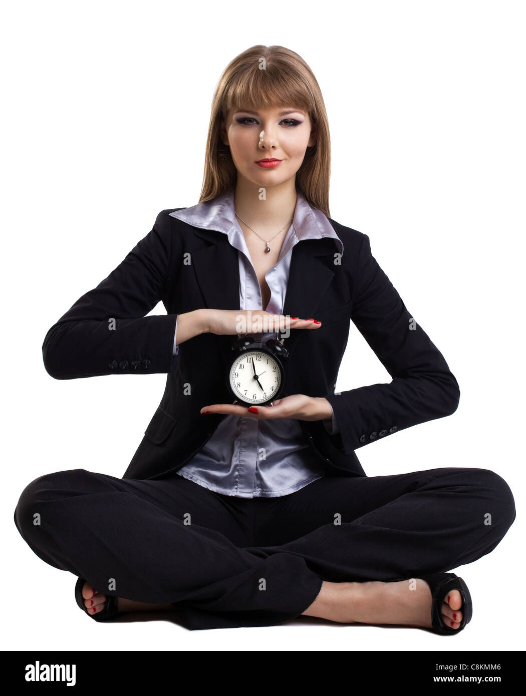 Yong business woman sit in yoga pose with clock - isolated Stock Photo ...