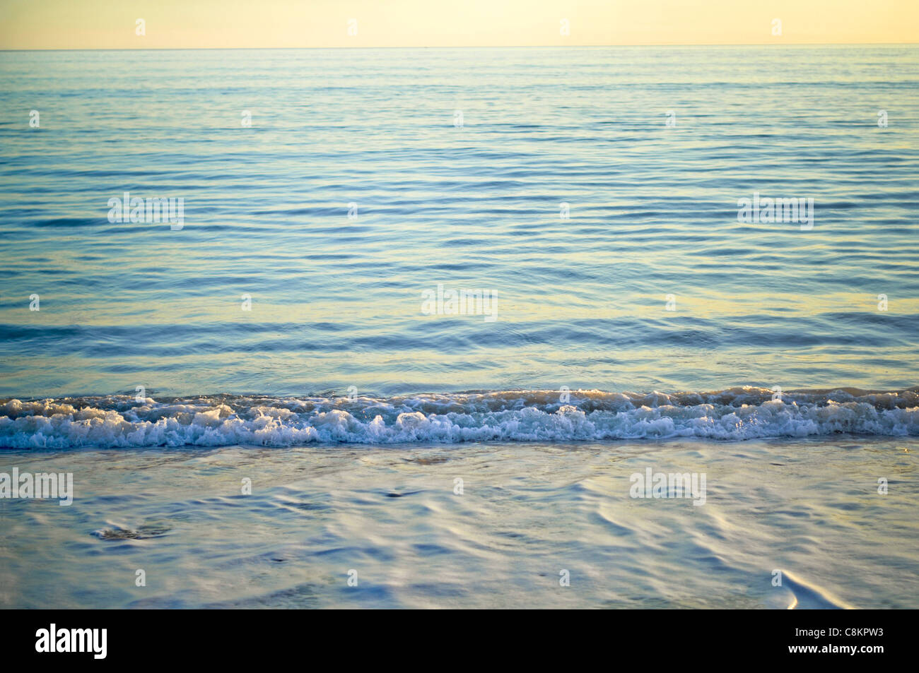 Gentle surf at serene sunset Stock Photo - Alamy