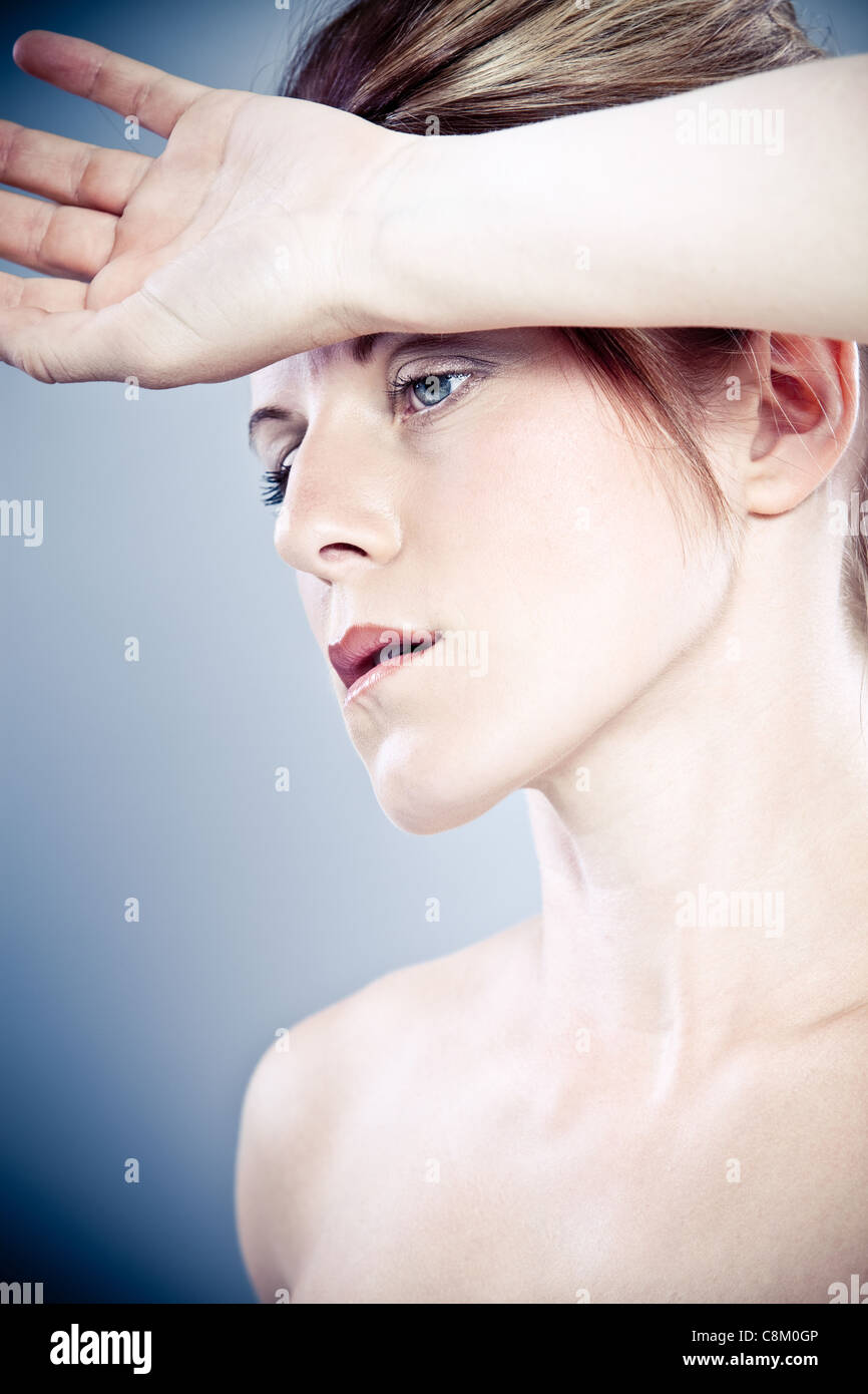 Beauty portrait of a young woman holding hand to her forehead Stock ...