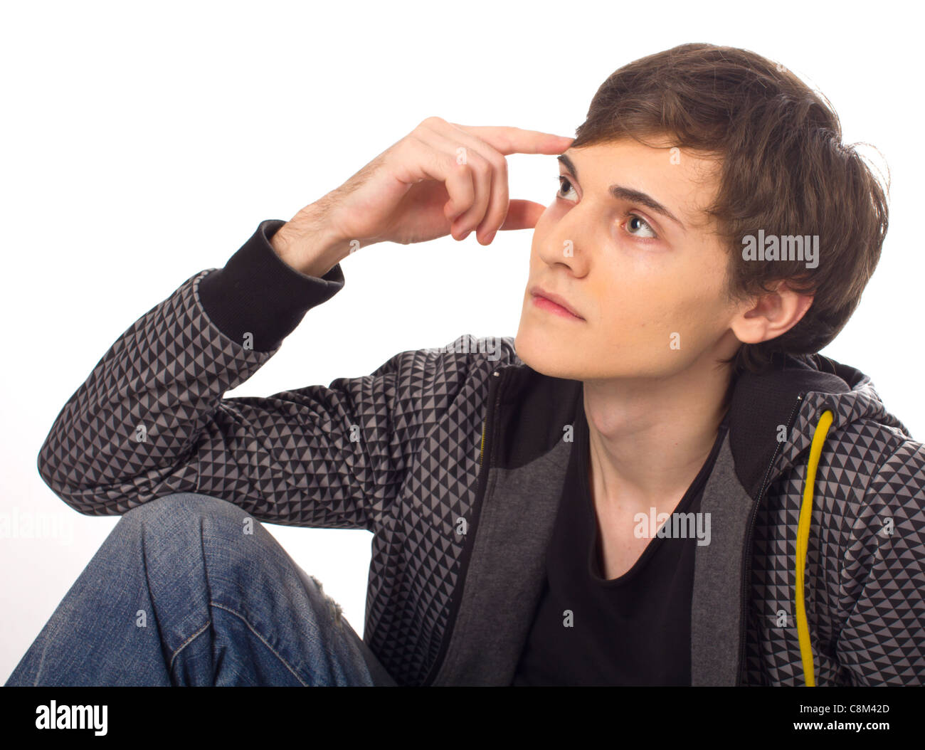 Handsome young man sitting and thinking on white background Stock Photo ...