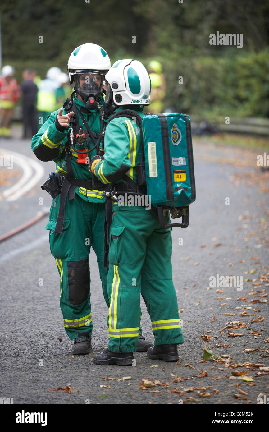 Paramedics wearing oxygen masks attend a road traffic accident ...