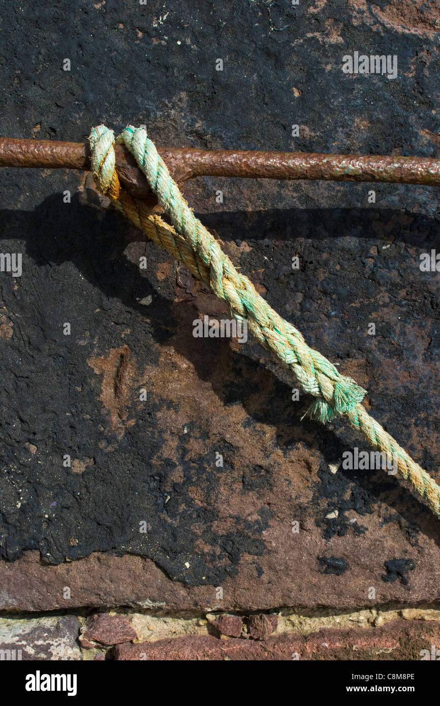 A mooring rope tied to an old iron railing at a Scottish harbour Stock ...