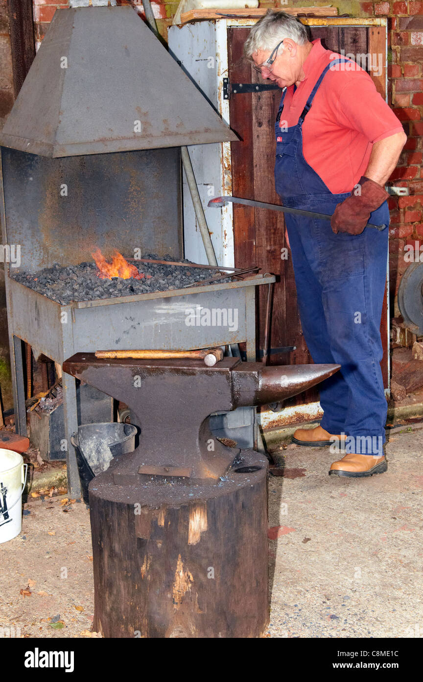 Blacksmith at work using a typical portable steel forge and traditional ...