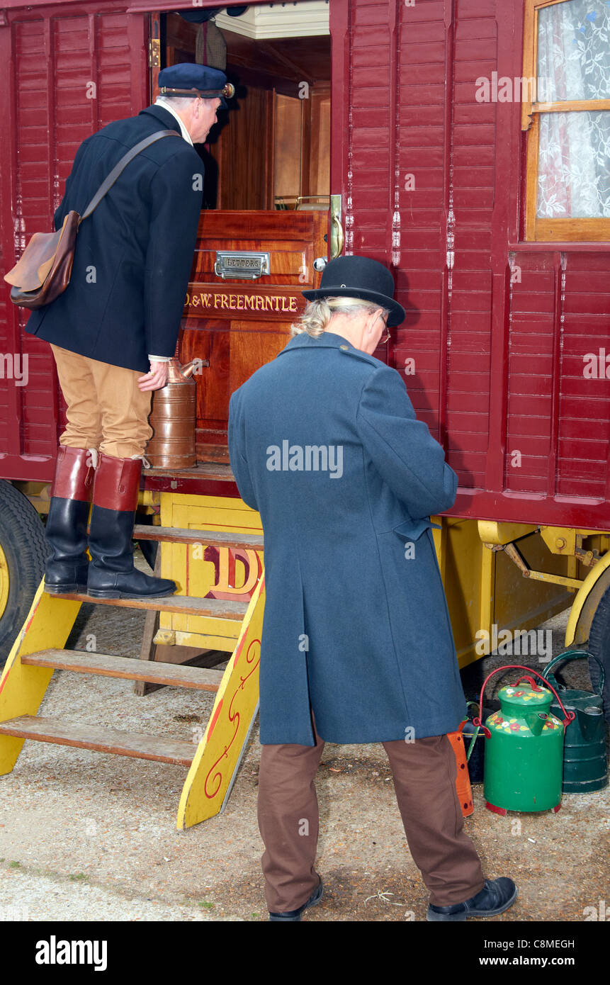 Two people in Edwardian clothing inspect a traveling showman's living ...