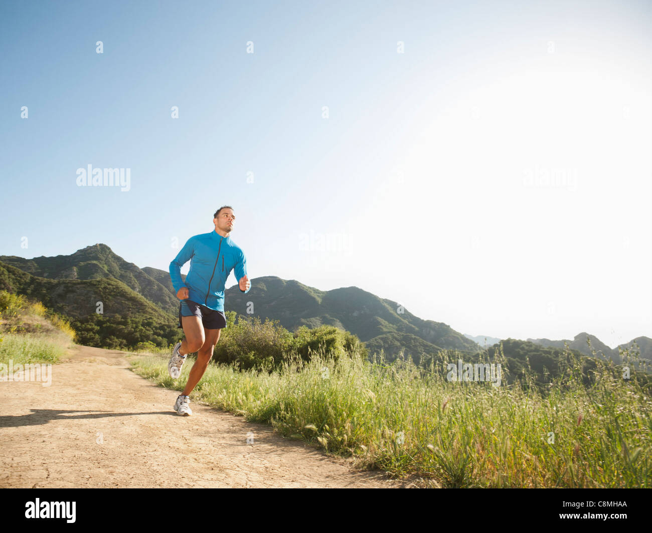 Mixed race man running on remote trail Stock Photo - Alamy