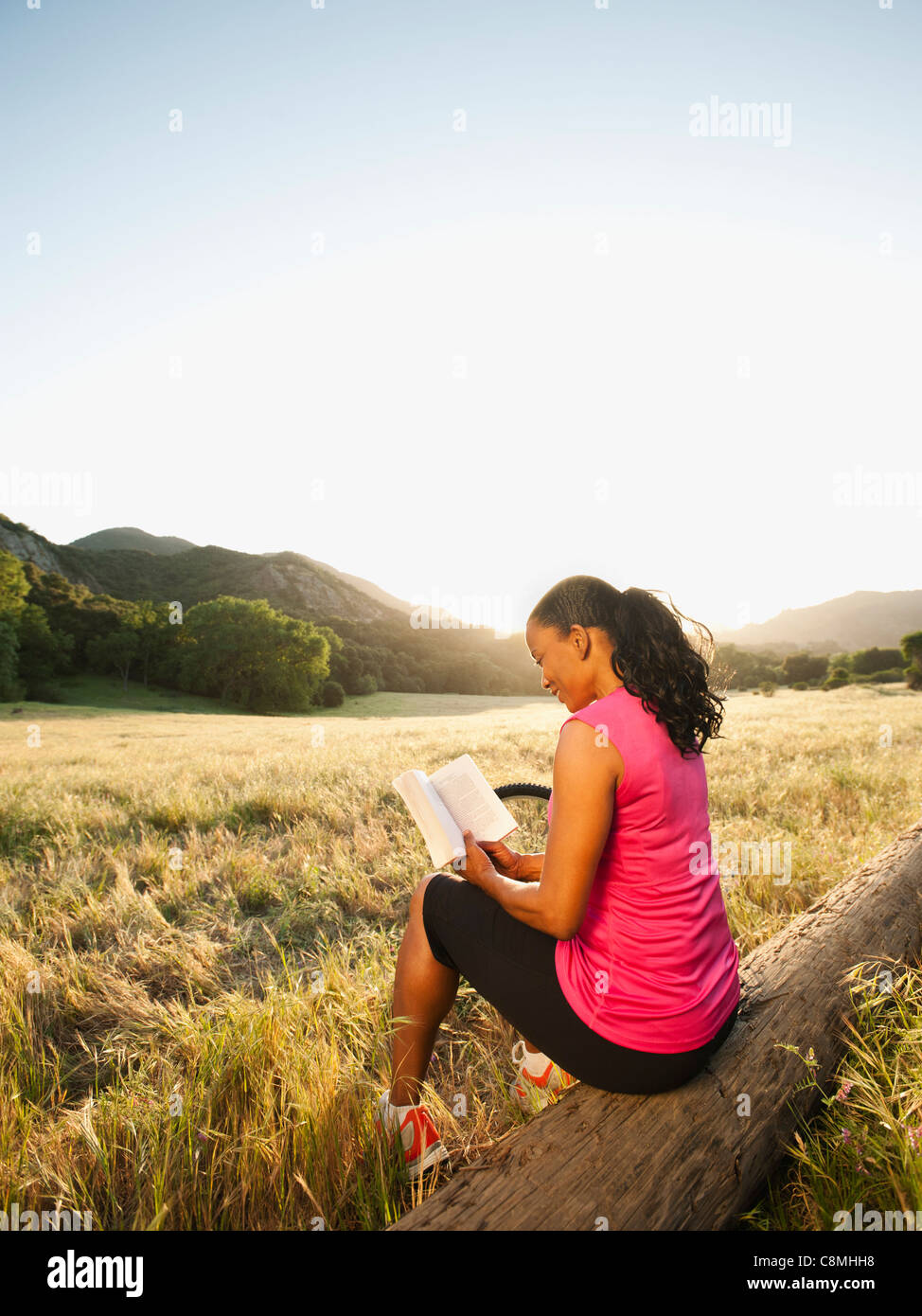 Black woman reading book in remote area Stock Photo - Alamy