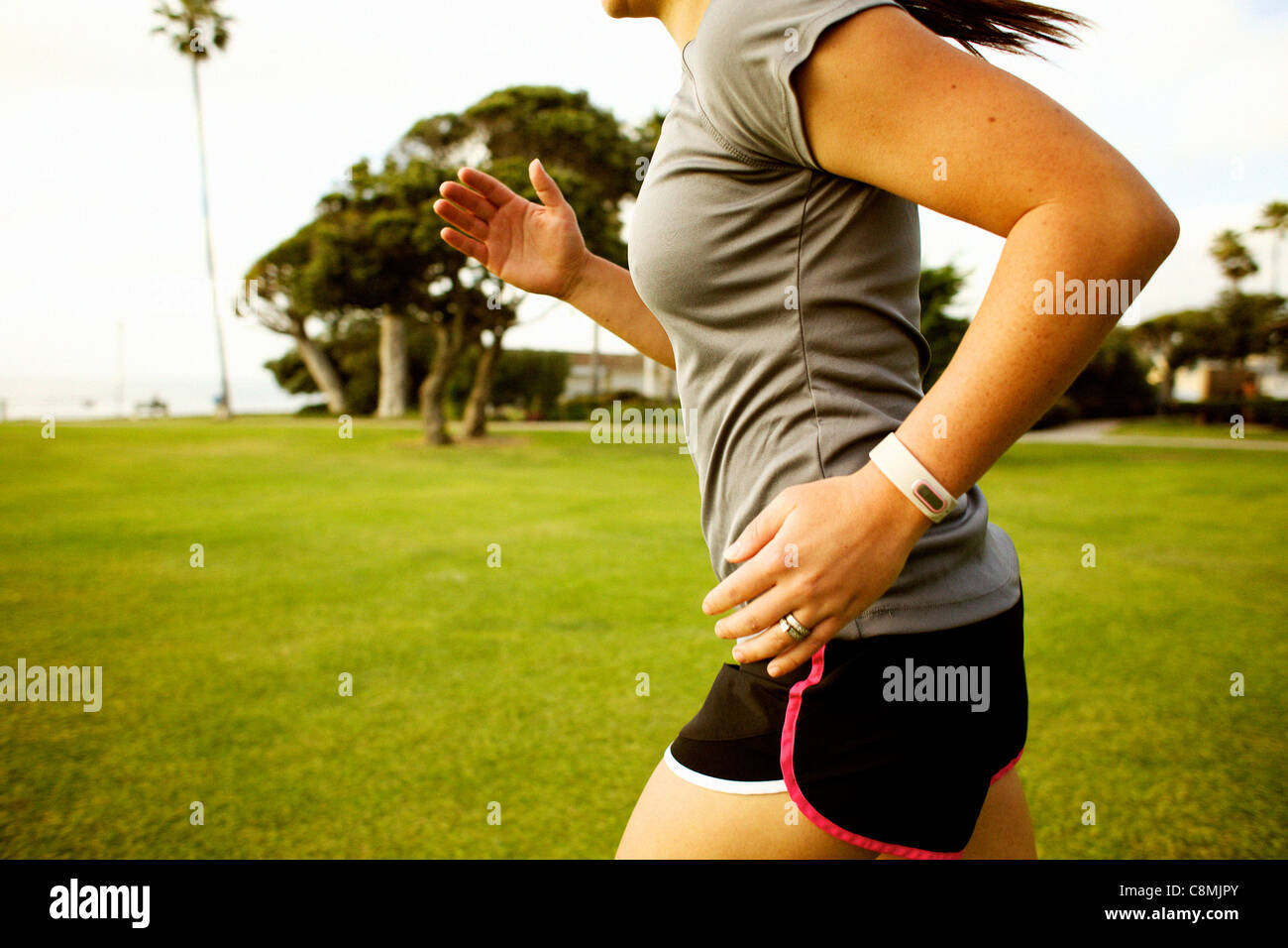Hispanic woman running in park field Stock Photo - Alamy