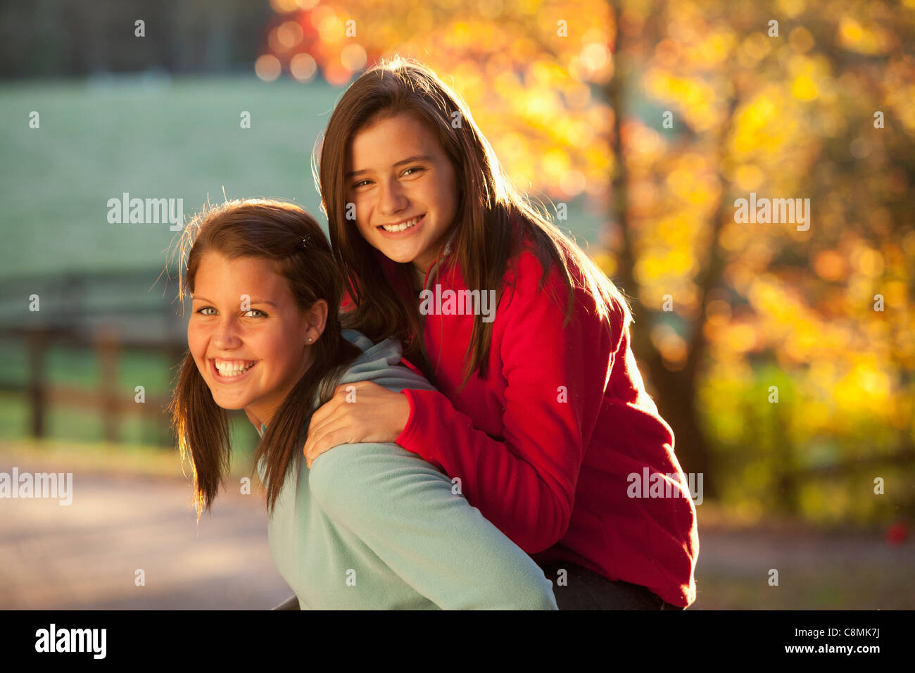 Caucasian girl carrying friend on her back Stock Photo - Alamy