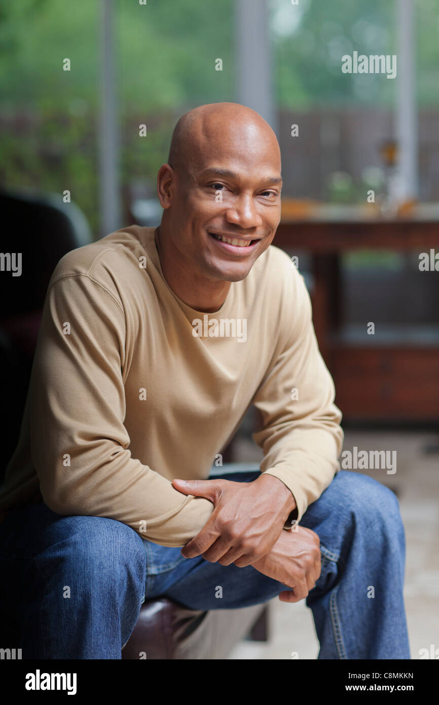 Smiling Black man sitting in chair Stock Photo - Alamy