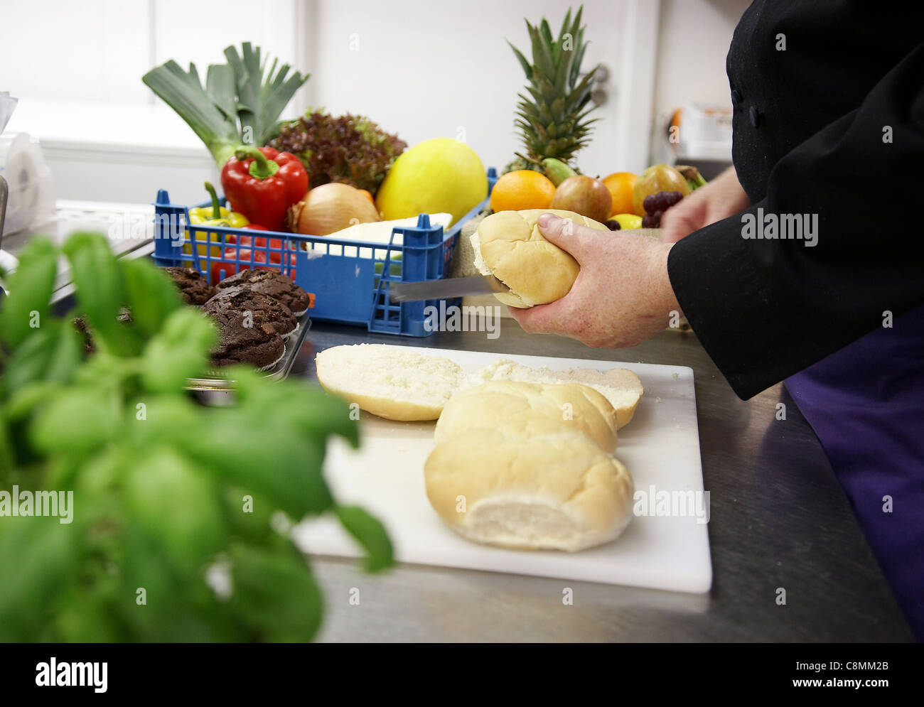 Chef cutting bread rolls in a works kitchen Stock Photo - Alamy