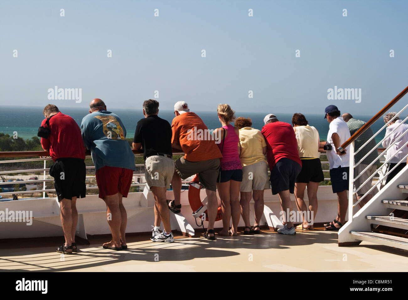 Group of people looking over railing Stock Photo - Alamy