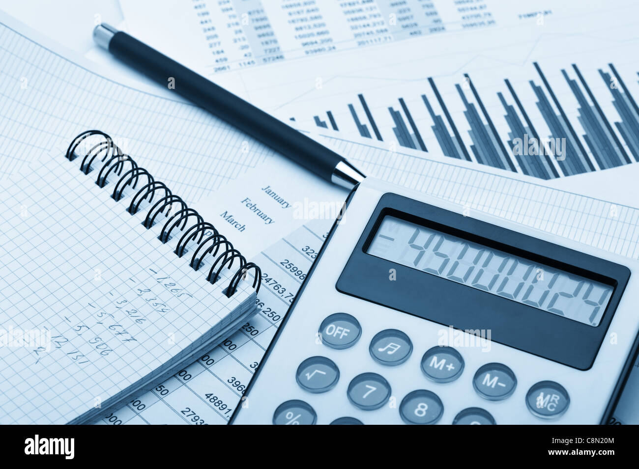 The calculator and the financial report blue toned. A workplace of the ...