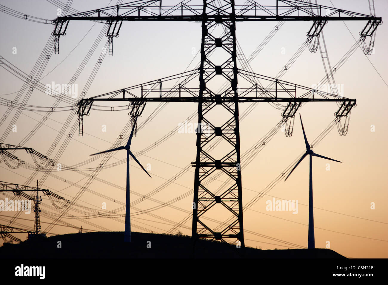 HIgh tension power lines, wind energy plant on a mining pile hill Stock ...
