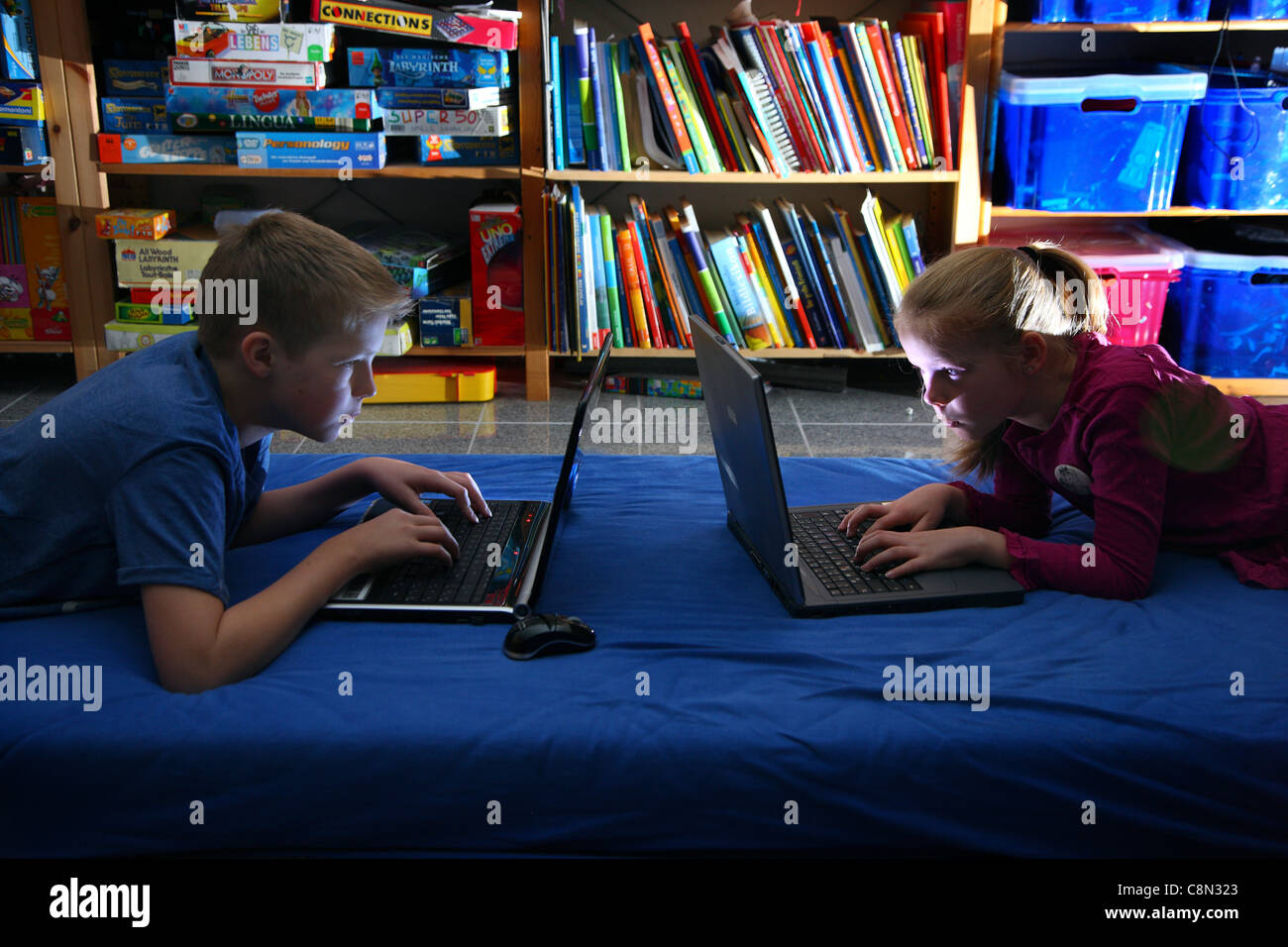 2 kids, girl 10, boy 13 years old, playing computer games on laptop ...