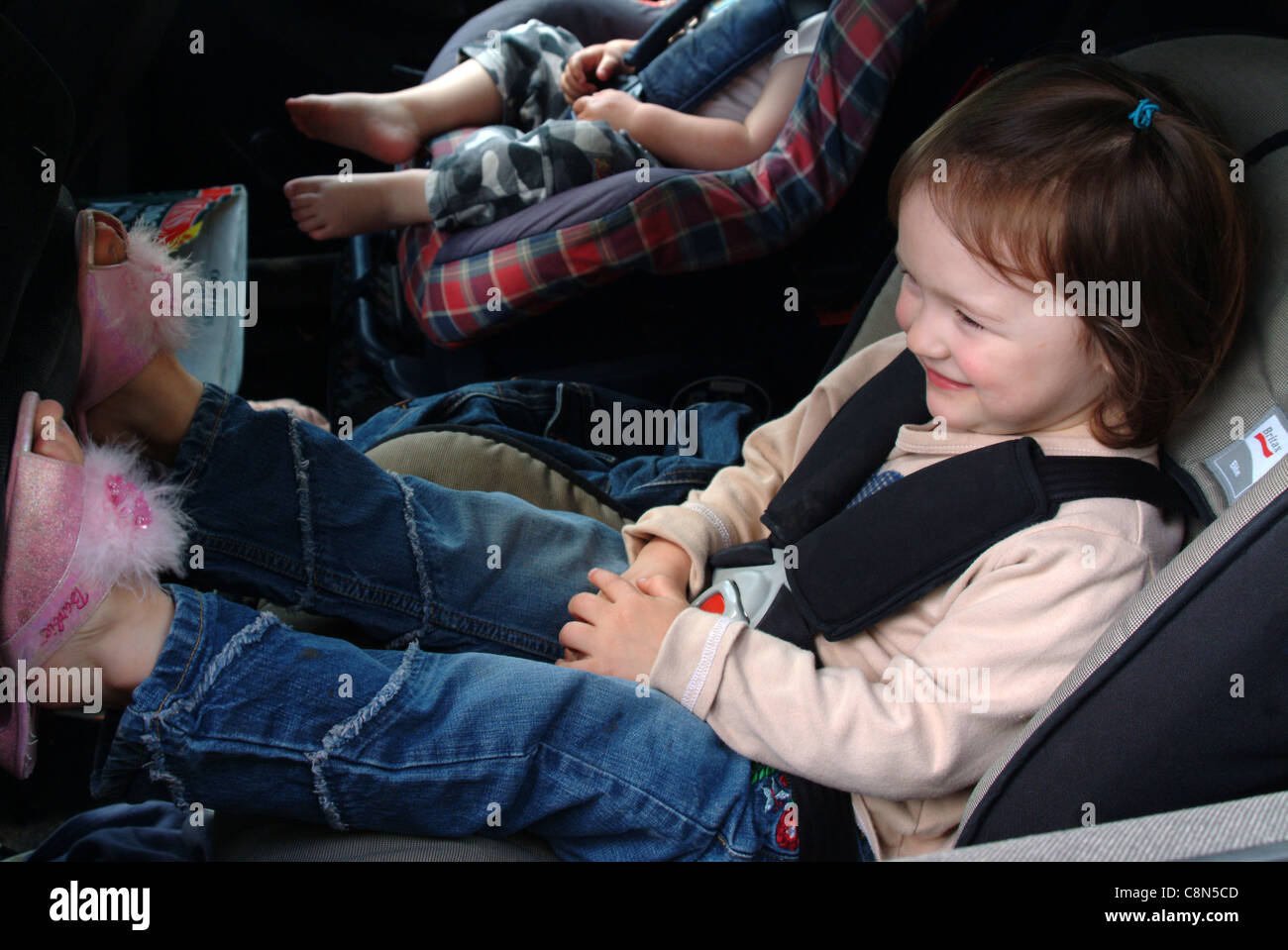 Children traveling in back of the car strapped into car seats Stock ...