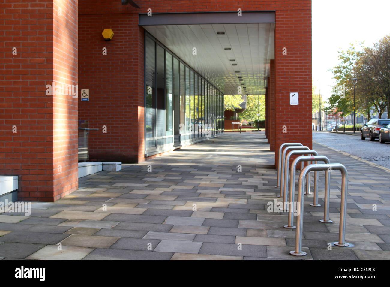 Outside an office block, paved sidewalk that passes under the buildings ...