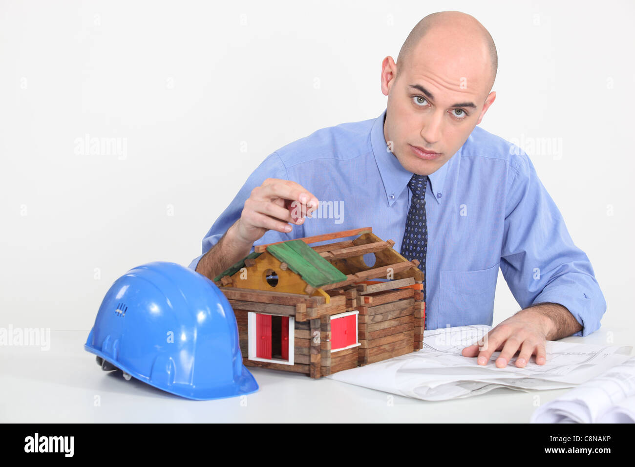 Architect sat with model house Stock Photo - Alamy