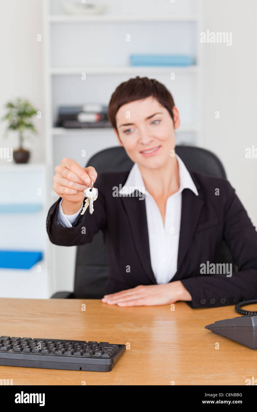 Portrait of an office worker showing keys Stock Photo - Alamy