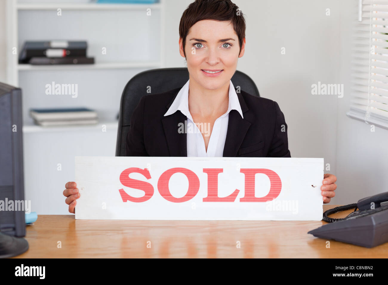 Cute real estate agent with a sold panel Stock Photo - Alamy