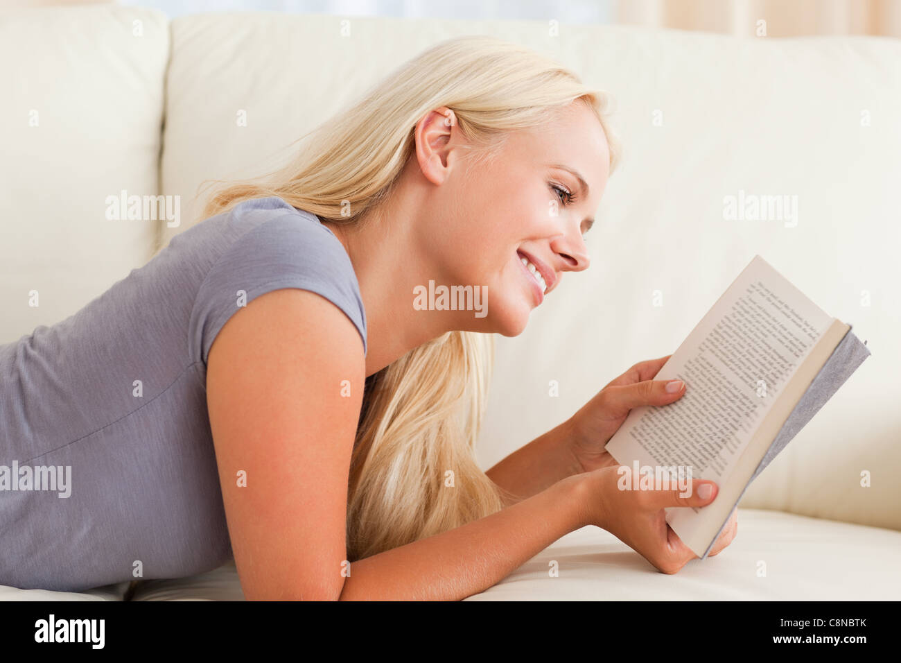 Smiling woman reading a book Stock Photo - Alamy