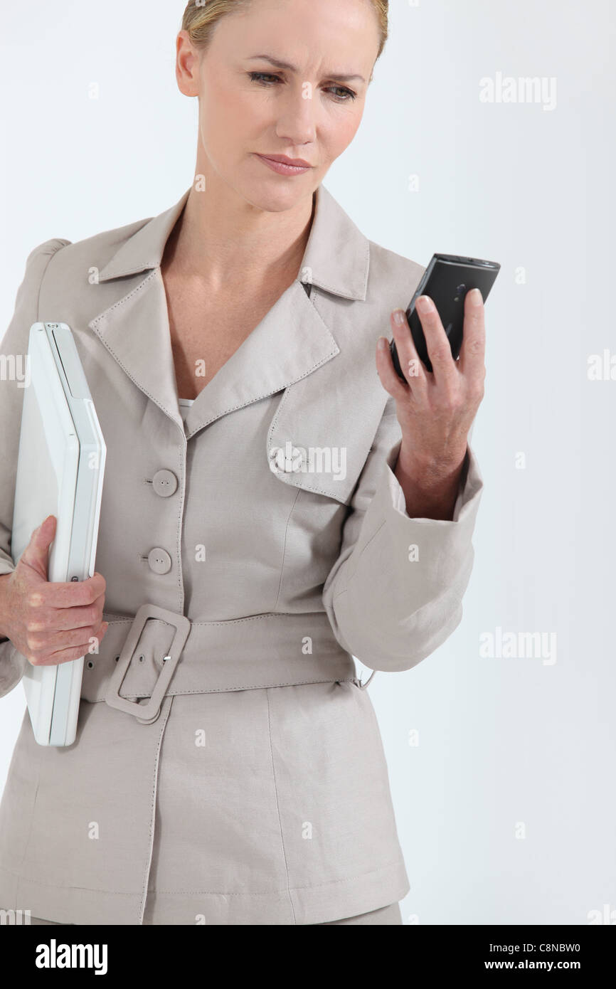 Female executive looking puzzled at her phone Stock Photo - Alamy