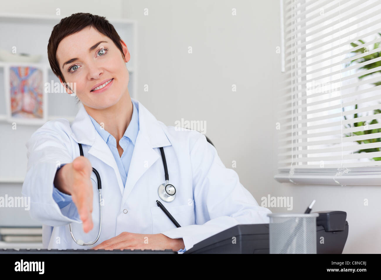Young female doctor giving her hand Stock Photo - Alamy
