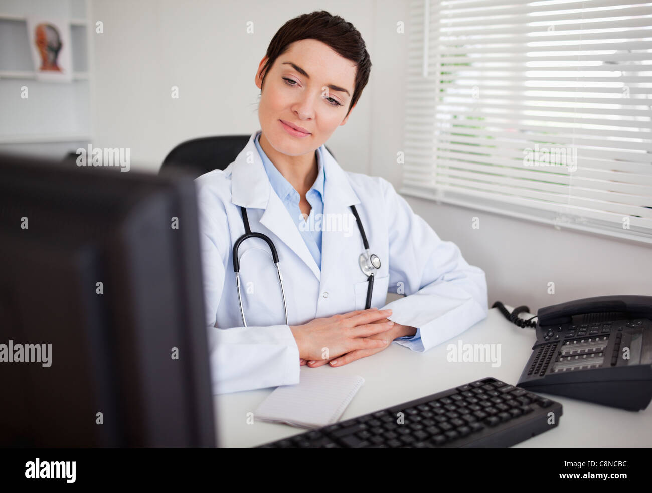 Serious female doctor looking at her computer Stock Photo - Alamy