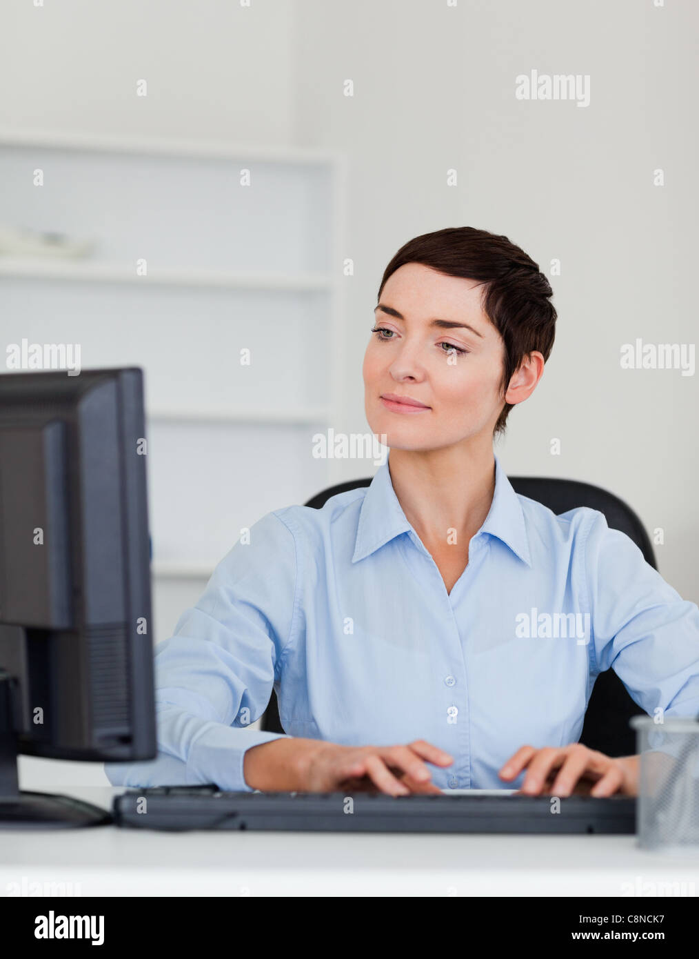 Portrait of a serious businesswoman typing wiht her computer Stock ...