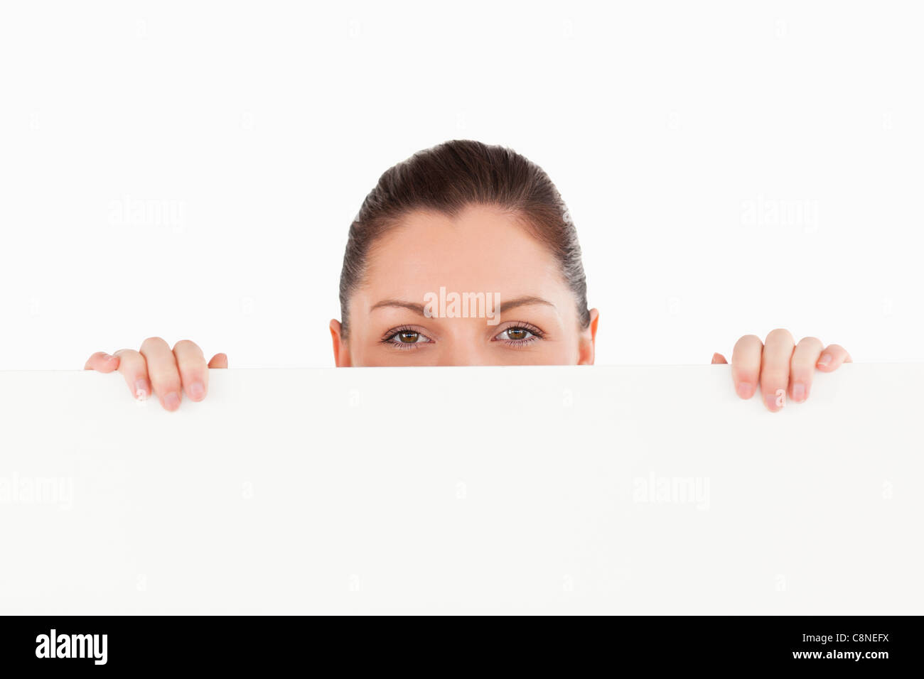 Portrait of a beautiful woman posing behind a billboard while standing ...