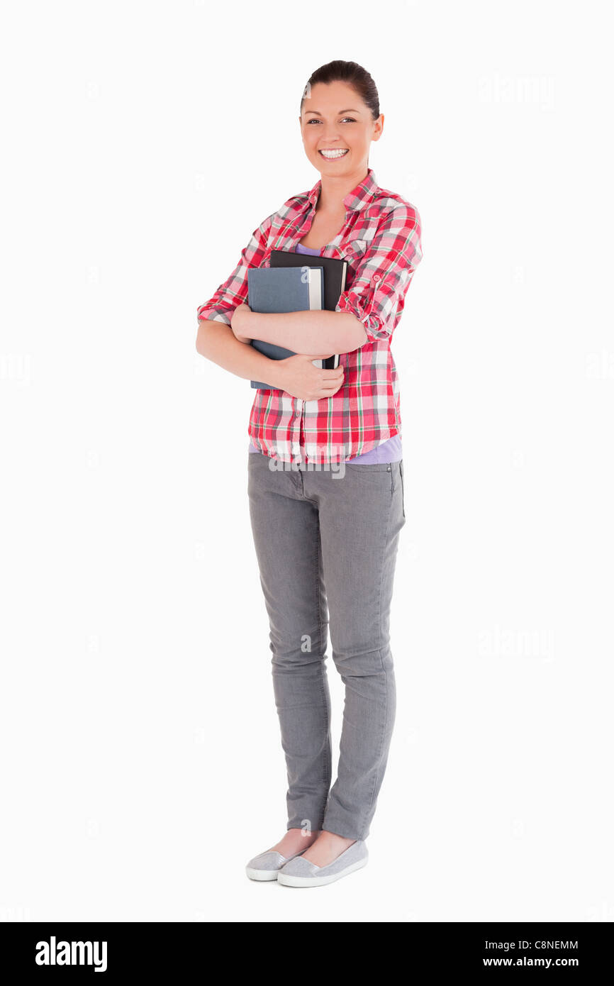 Attractive female posing with books while standing Stock Photo - Alamy