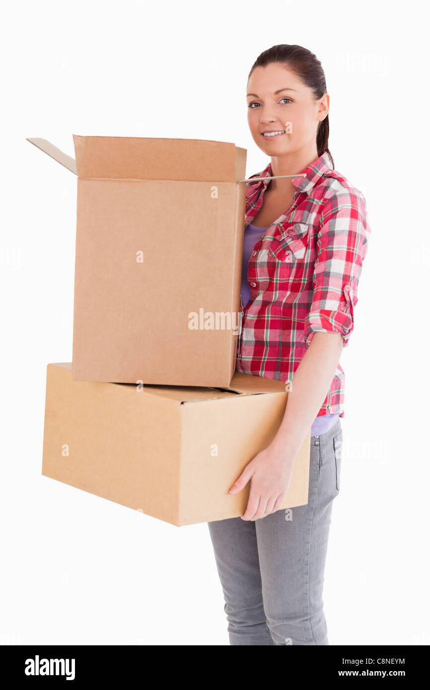 Attractive woman holding cardboard boxes while standing Stock Photo - Alamy